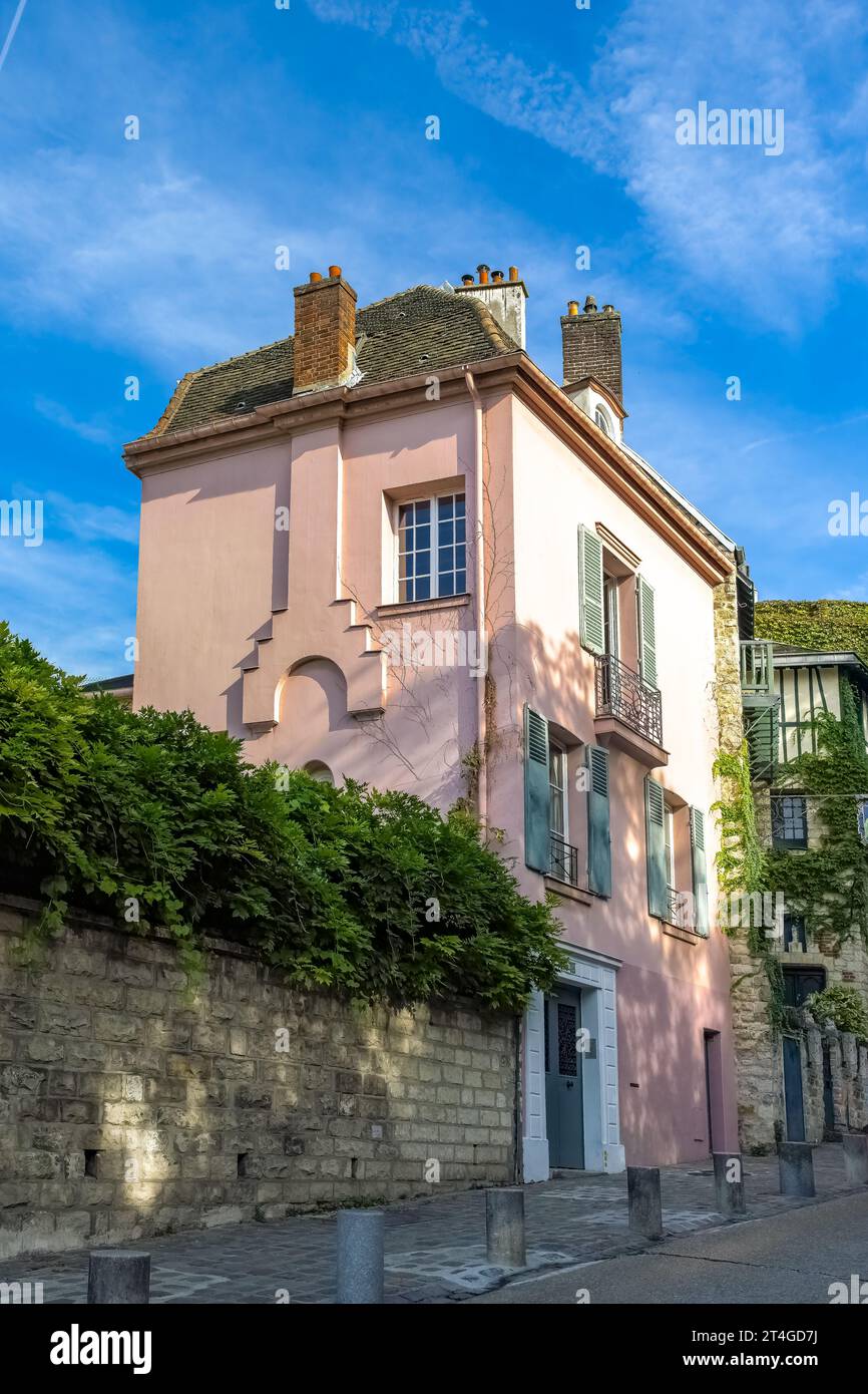 Paris, France, famous pink house in Montmartre, in a typical street ...
