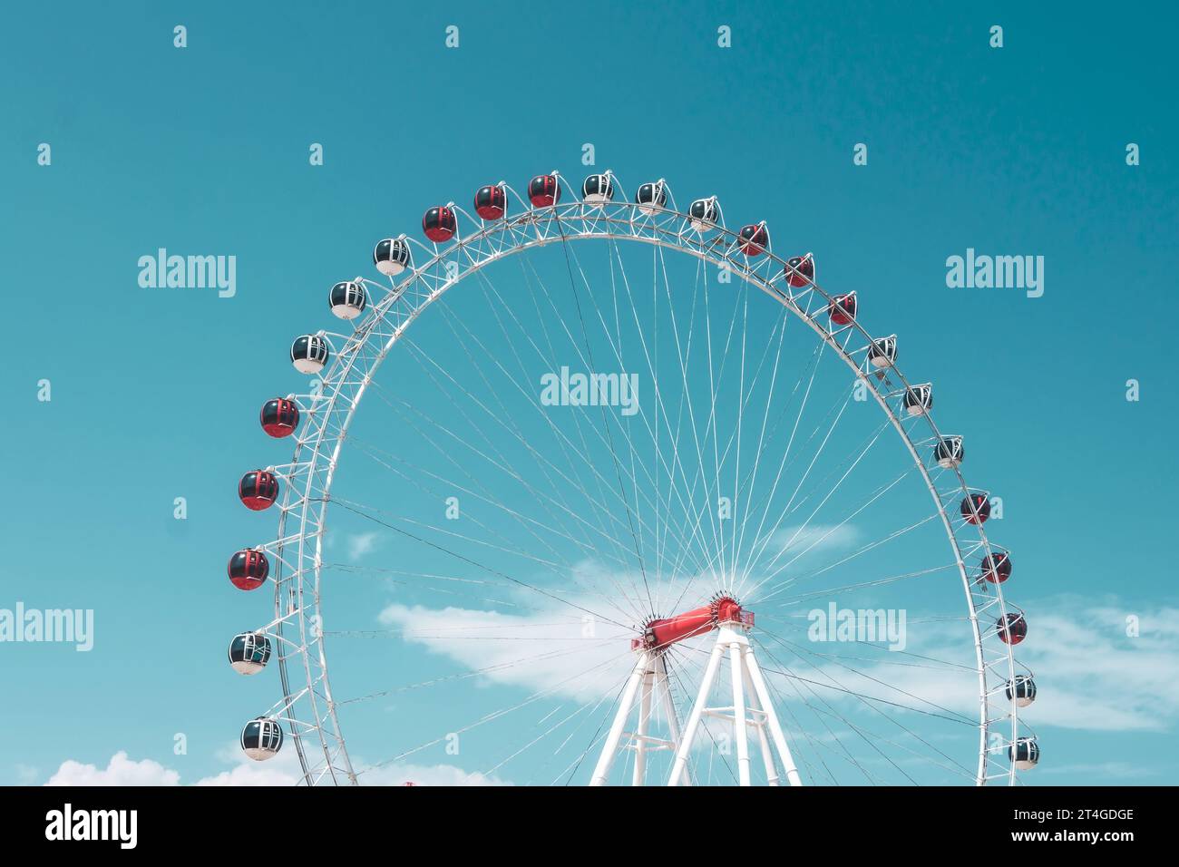 Red and white booths on top a white Ferris wheel against the sky Stock ...
