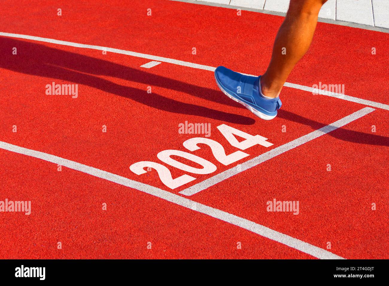 Runner crosses the finish line on a red treadmill with the numbers 2024 ...