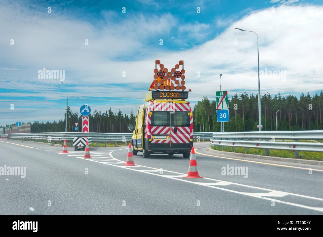 Toll road exit, closed turn separated by orange cones. A minibus with ...