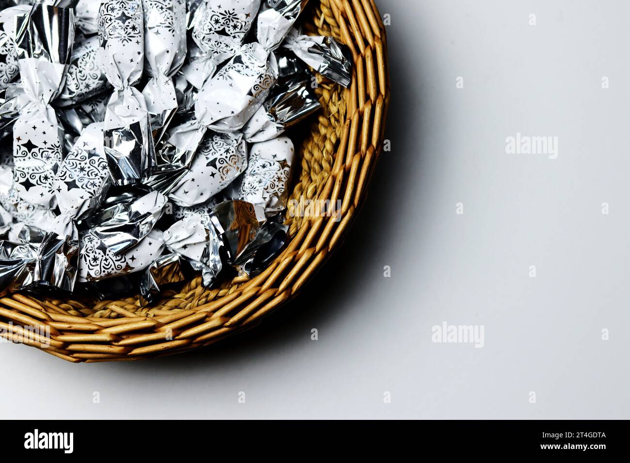 White packaged Christmas candies in a basket on a white background ...