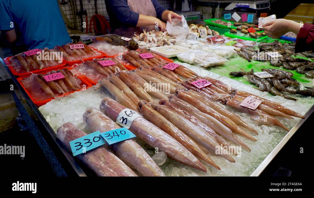 people is paying for fresh seafood. various squid, shrimp and fish on ...