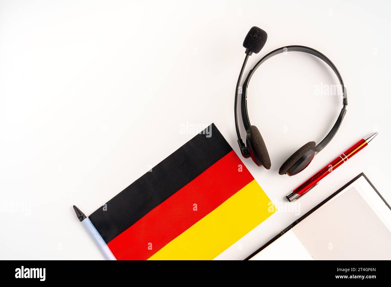 Notepad with German flag and headphones on white background. German ...