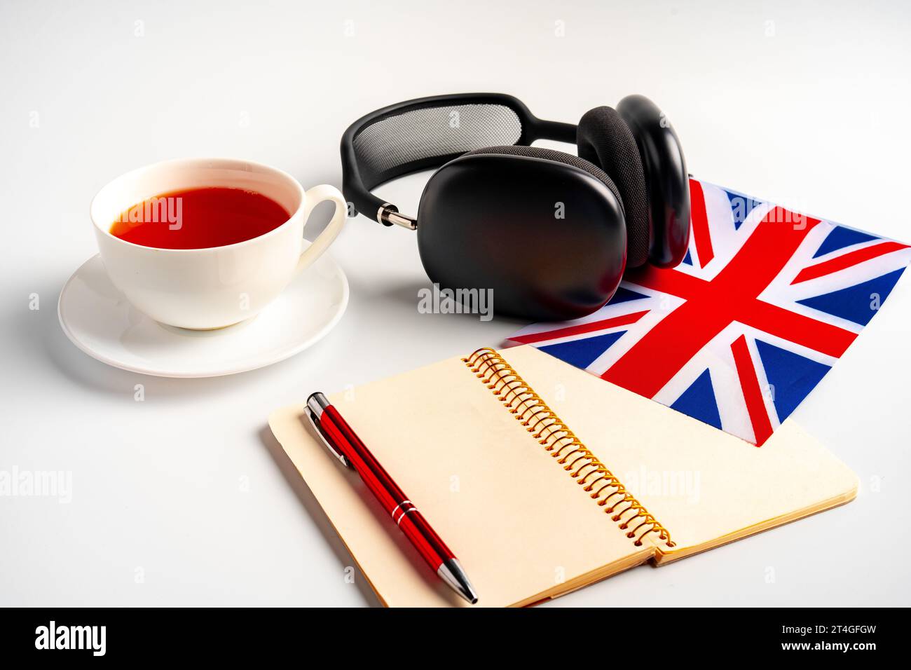 Notepad with British flag and headphones on white background. English ...