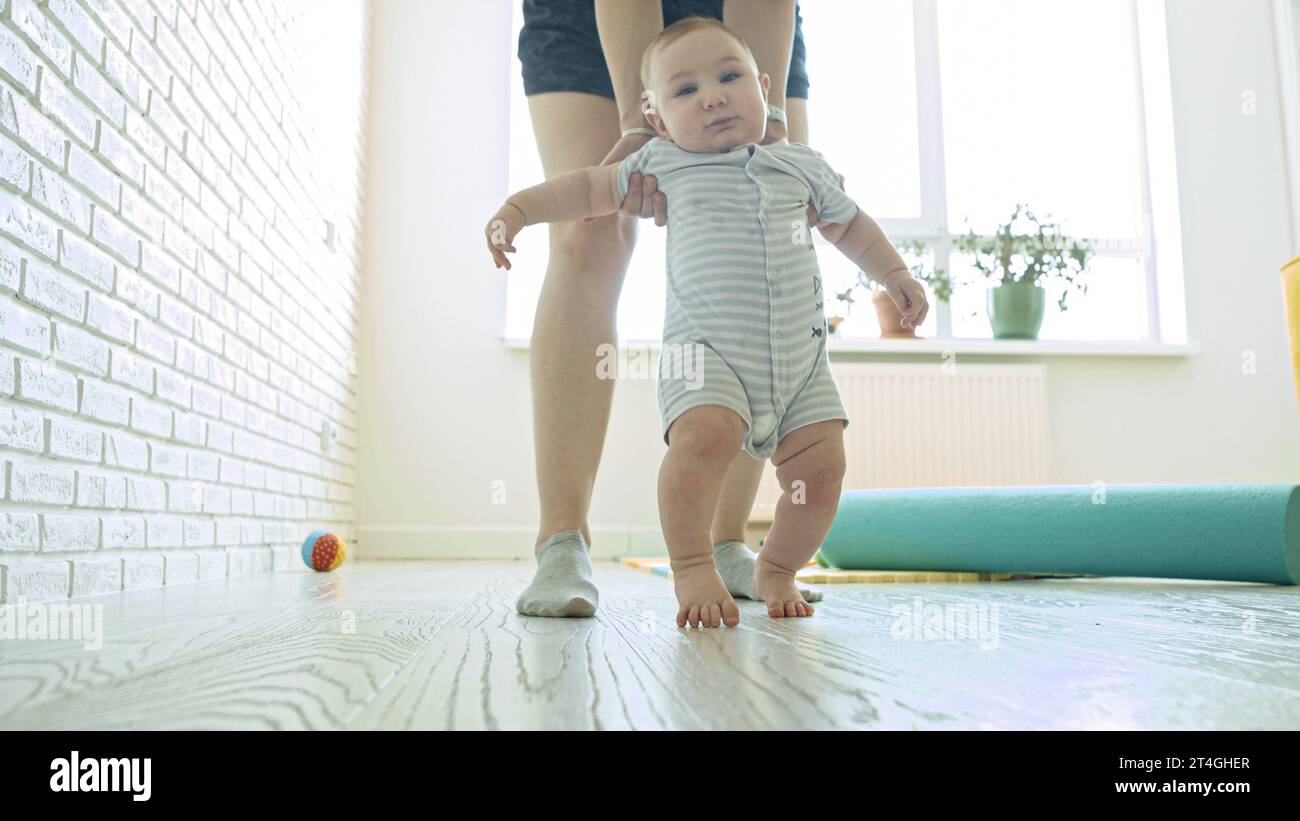 Mother teaching her baby how to walk Stock Photo - Alamy
