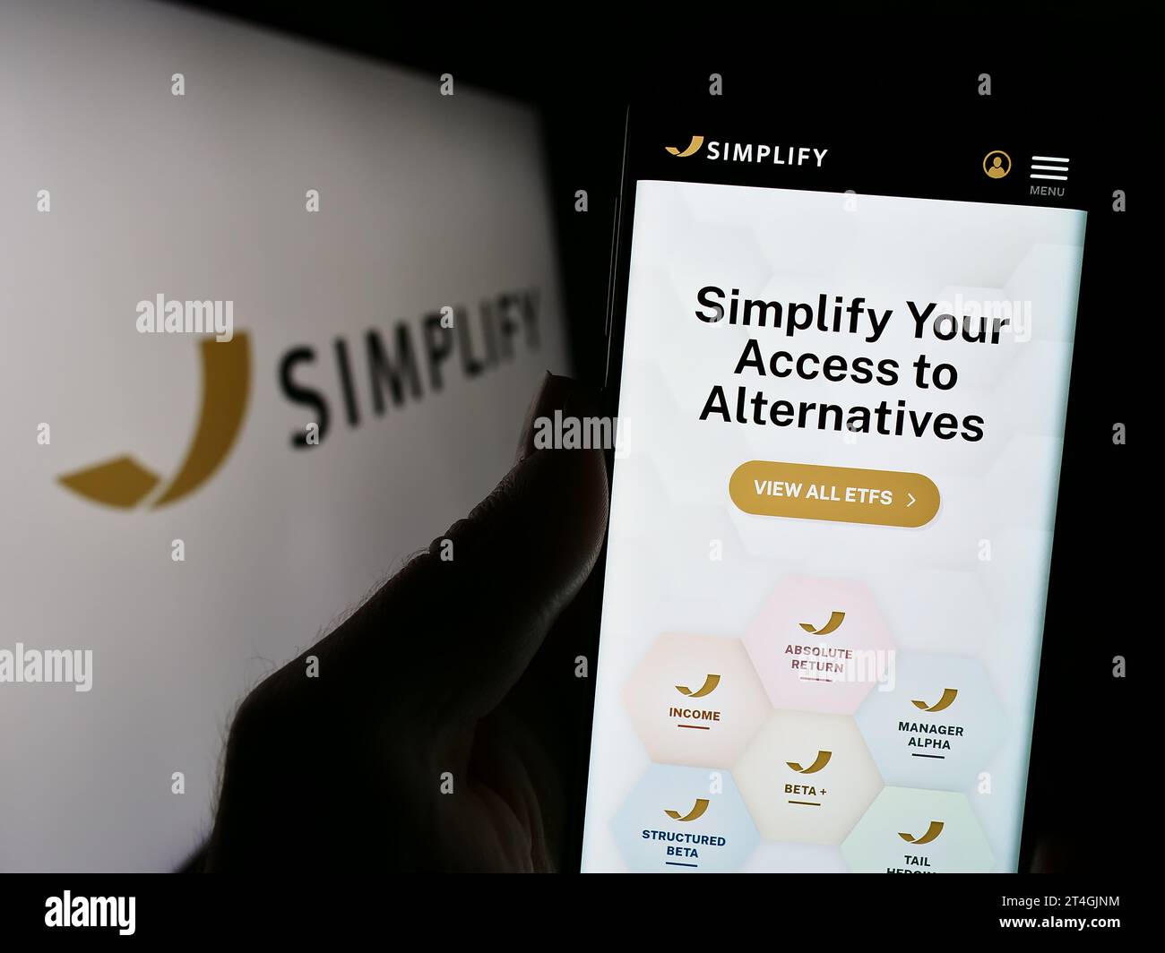 Person holding cellphone with webpage of US investment company Simplify ...