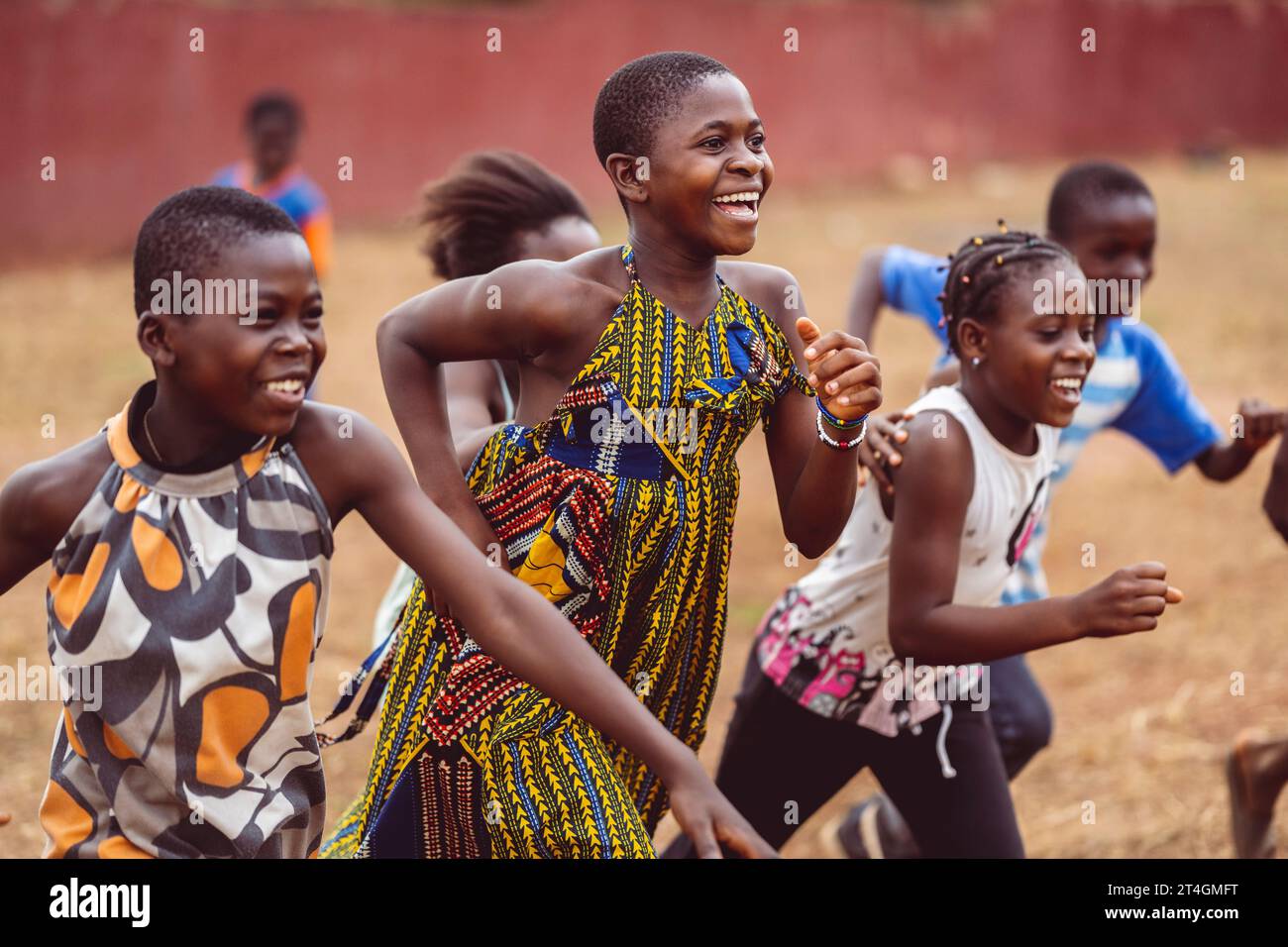 The young African children running in an outdoor setting in the city of ...