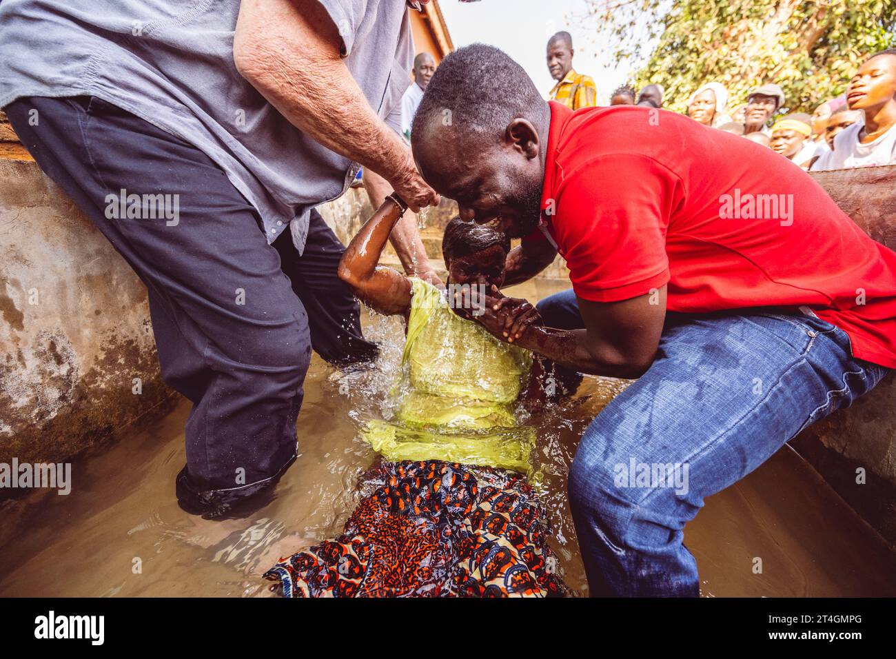 A group of joyous people celebrating a religious baptism ceremony in ...