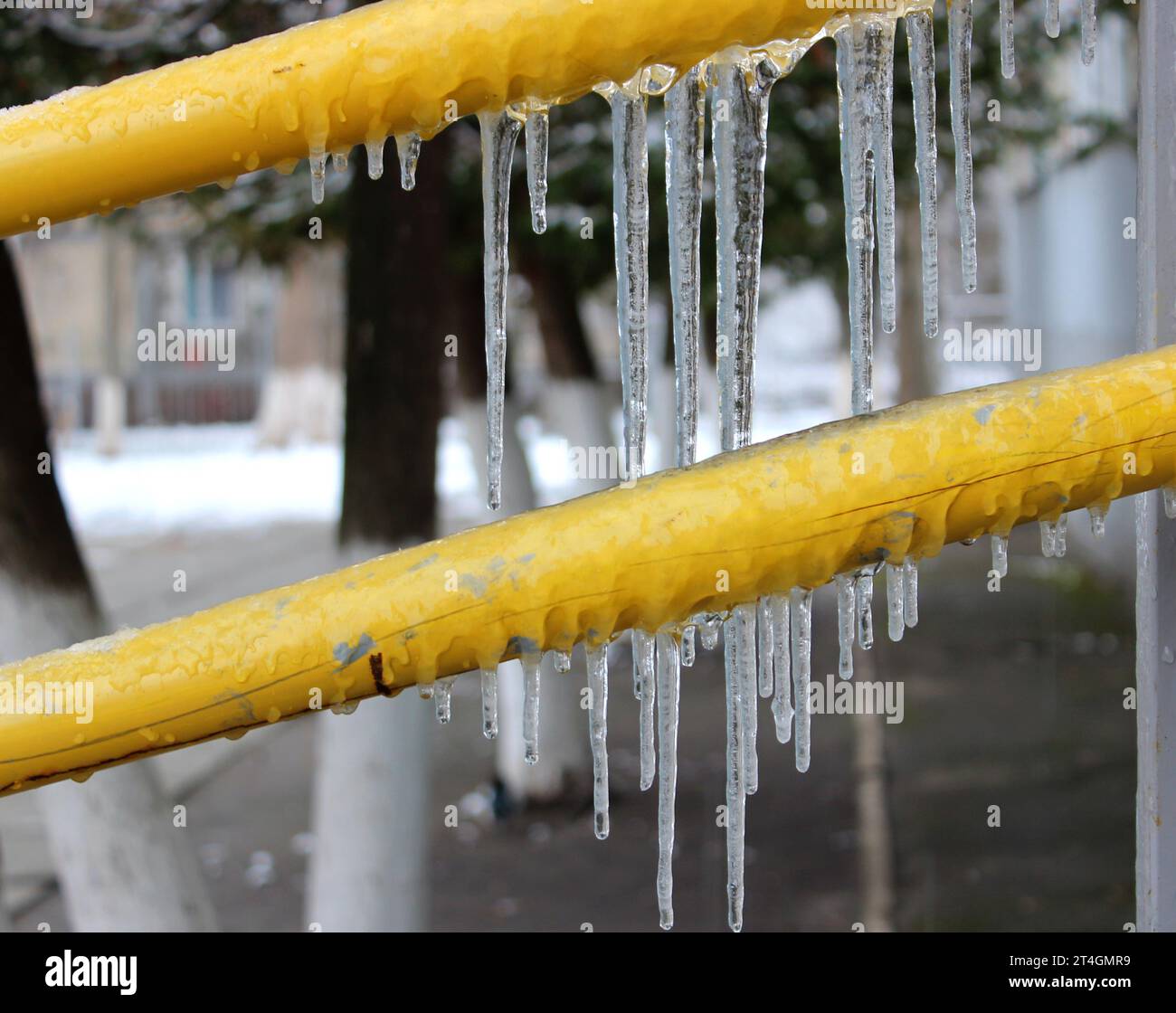 Icy handrails with frozen icicles near the entrance to a private house ...
