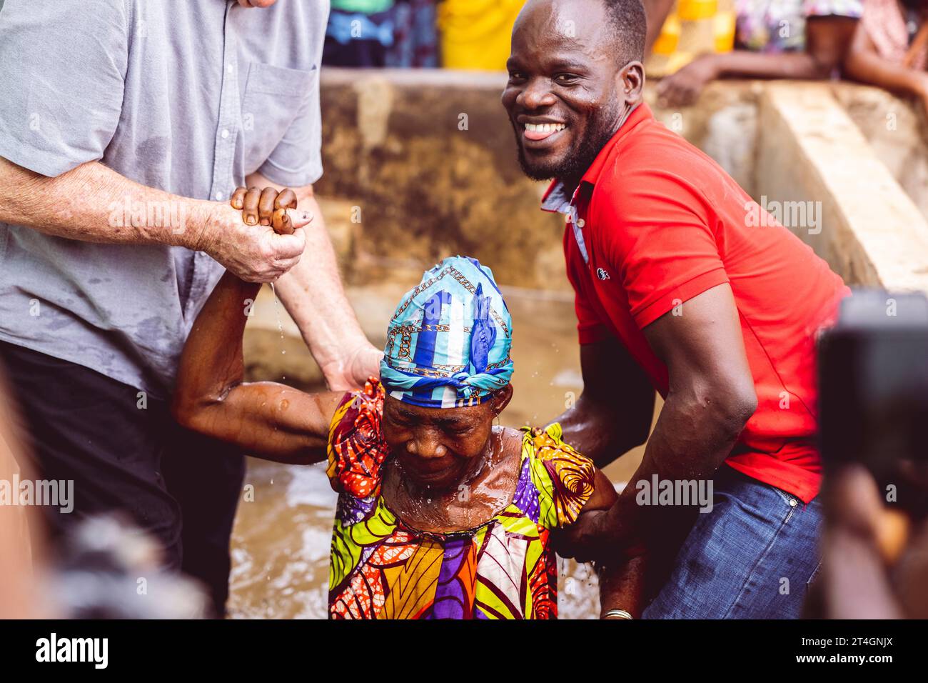 A group of joyous people celebrating a religious baptism ceremony in ...