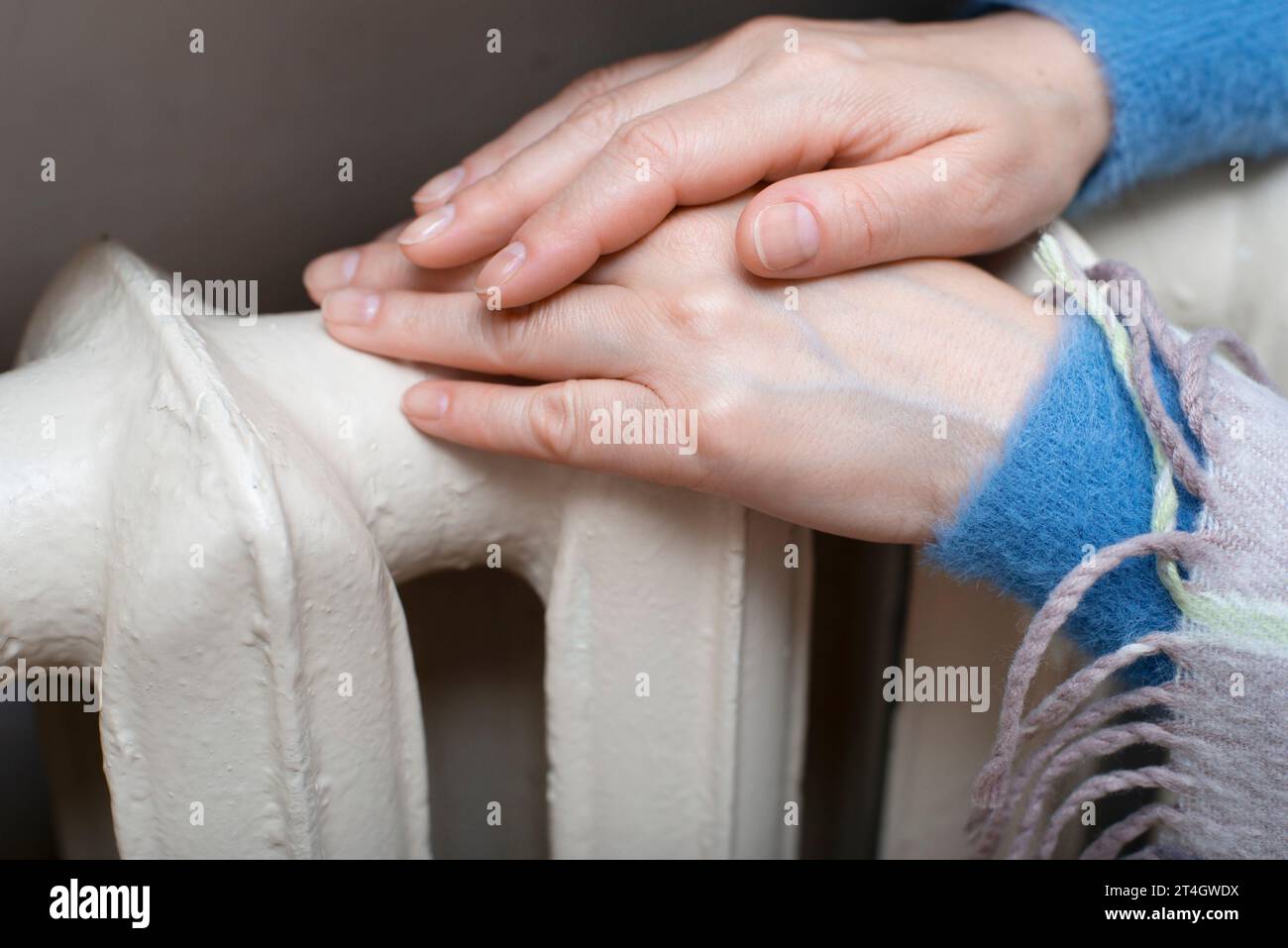 Caucasian female holds her hands on Hot Water Radiator. Home heating ...