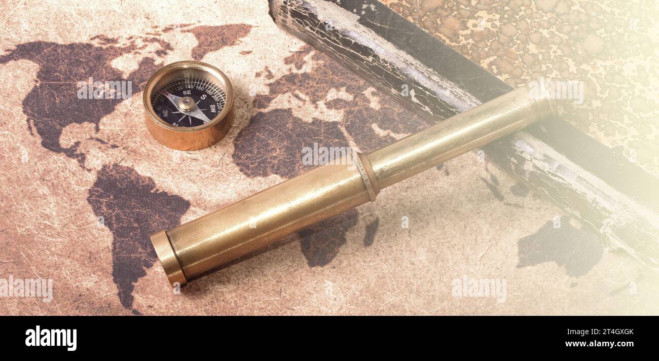 Compass, telescope and the book on the old map Stock Photo - Alamy