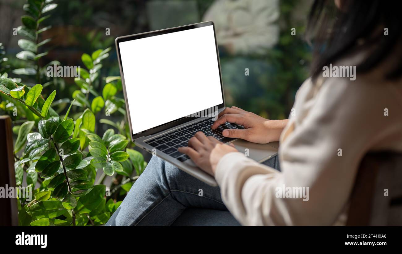 Close-up image of an Asian woman in casual clothes typing on keyboard ...