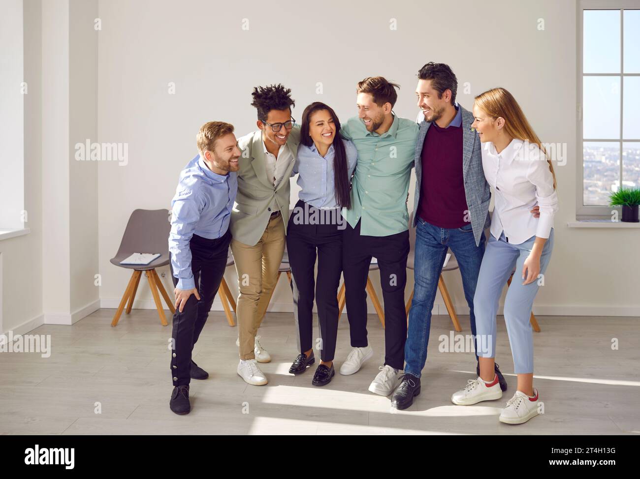 Group of happy business team hugging looking at each other Stock Photo ...