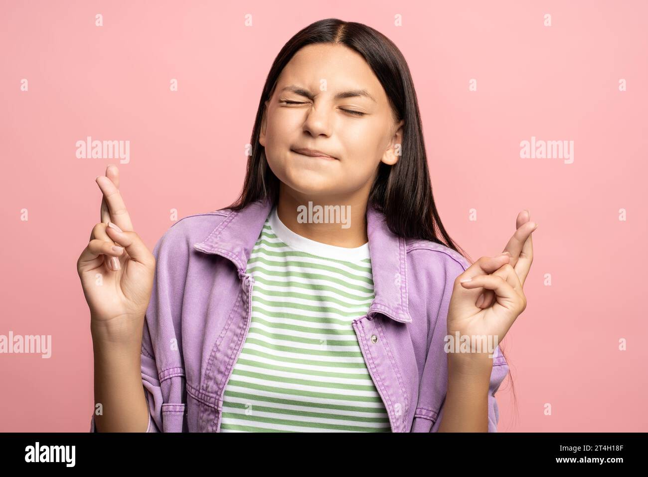 Dreaming smiling teenage girl making wish crossing fingers with closed ...