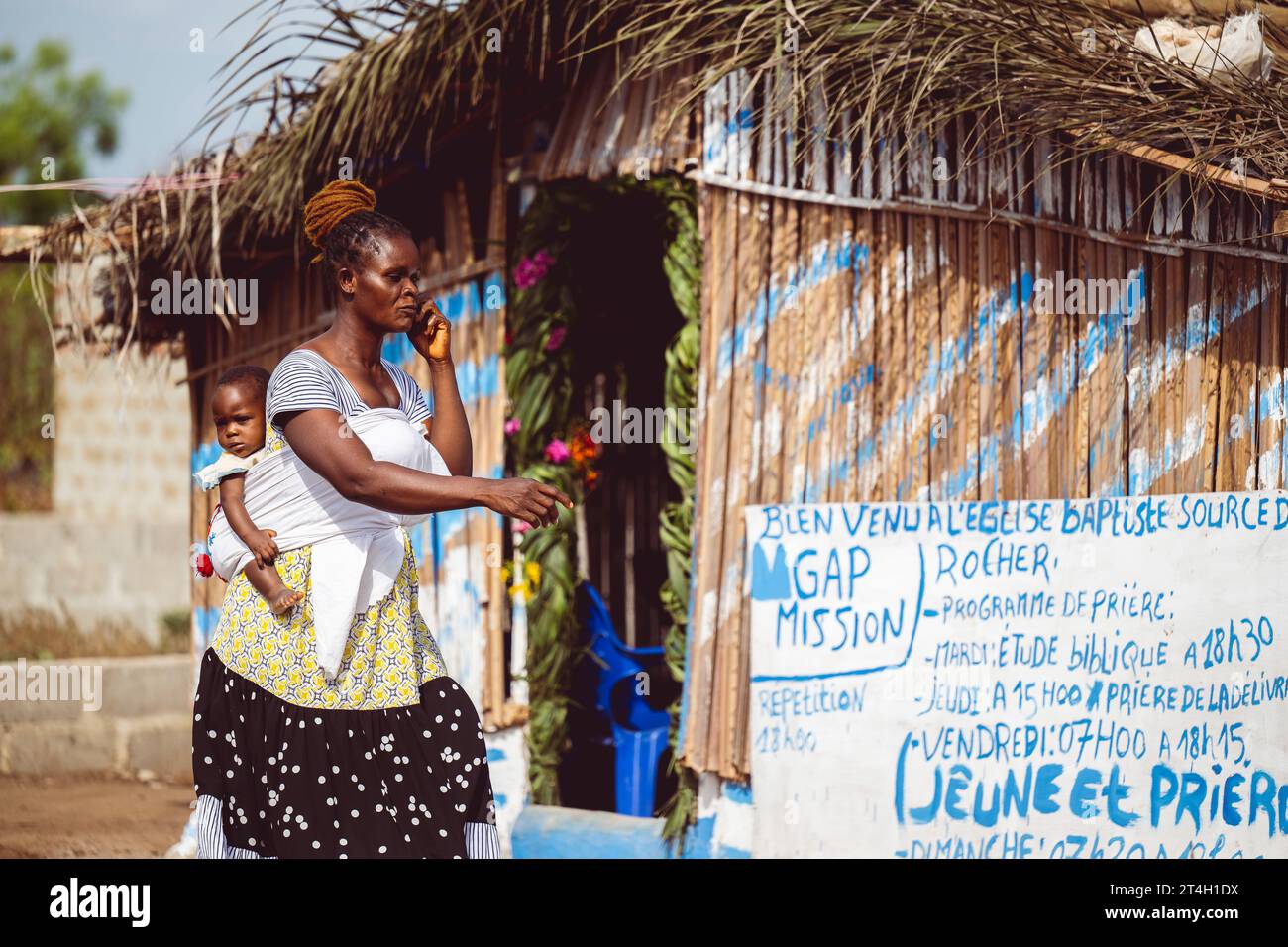 A close-up of an African woman talking on the phone, walking with a ...