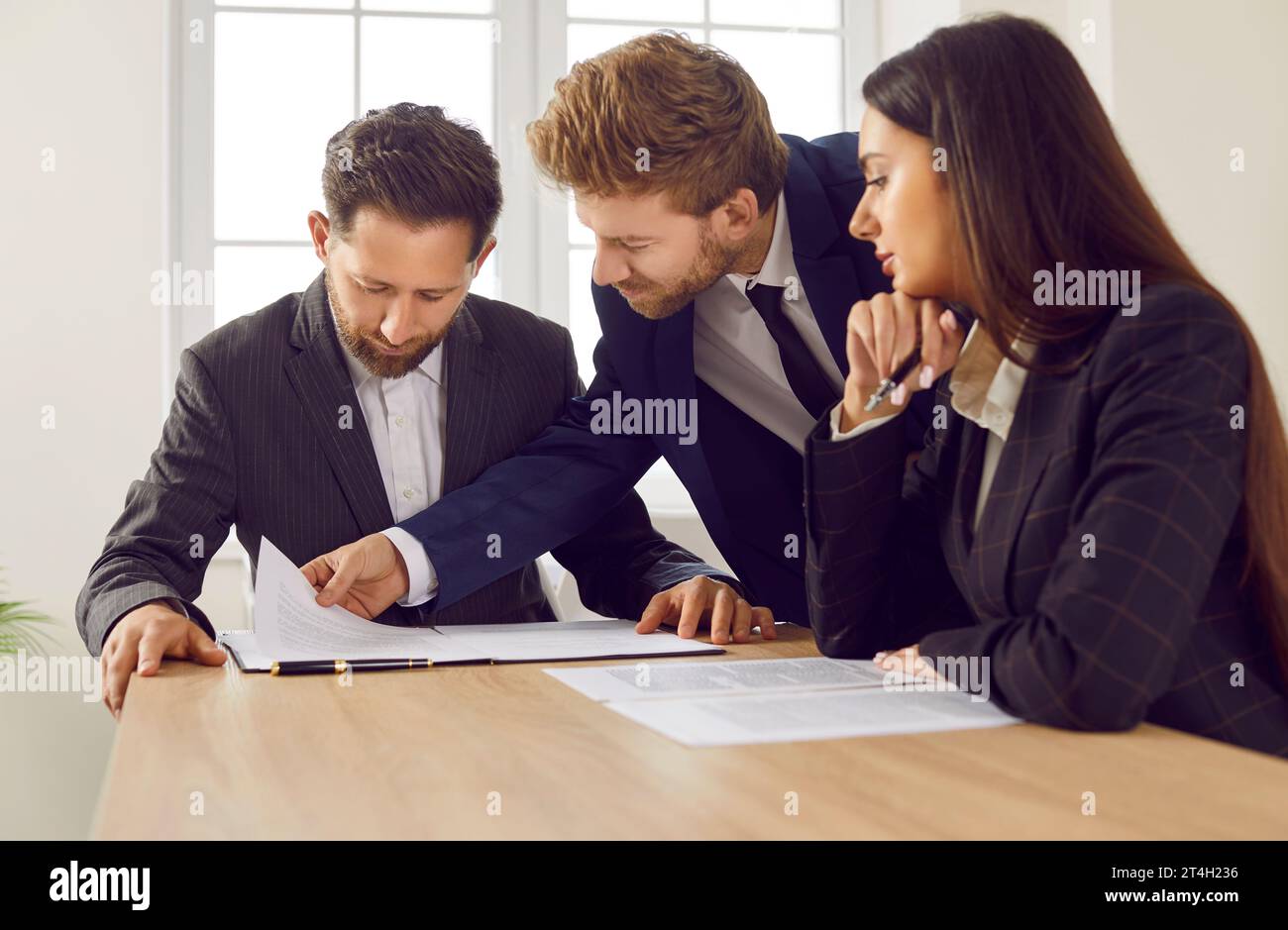 Business people looking through some documents and going sign a ...