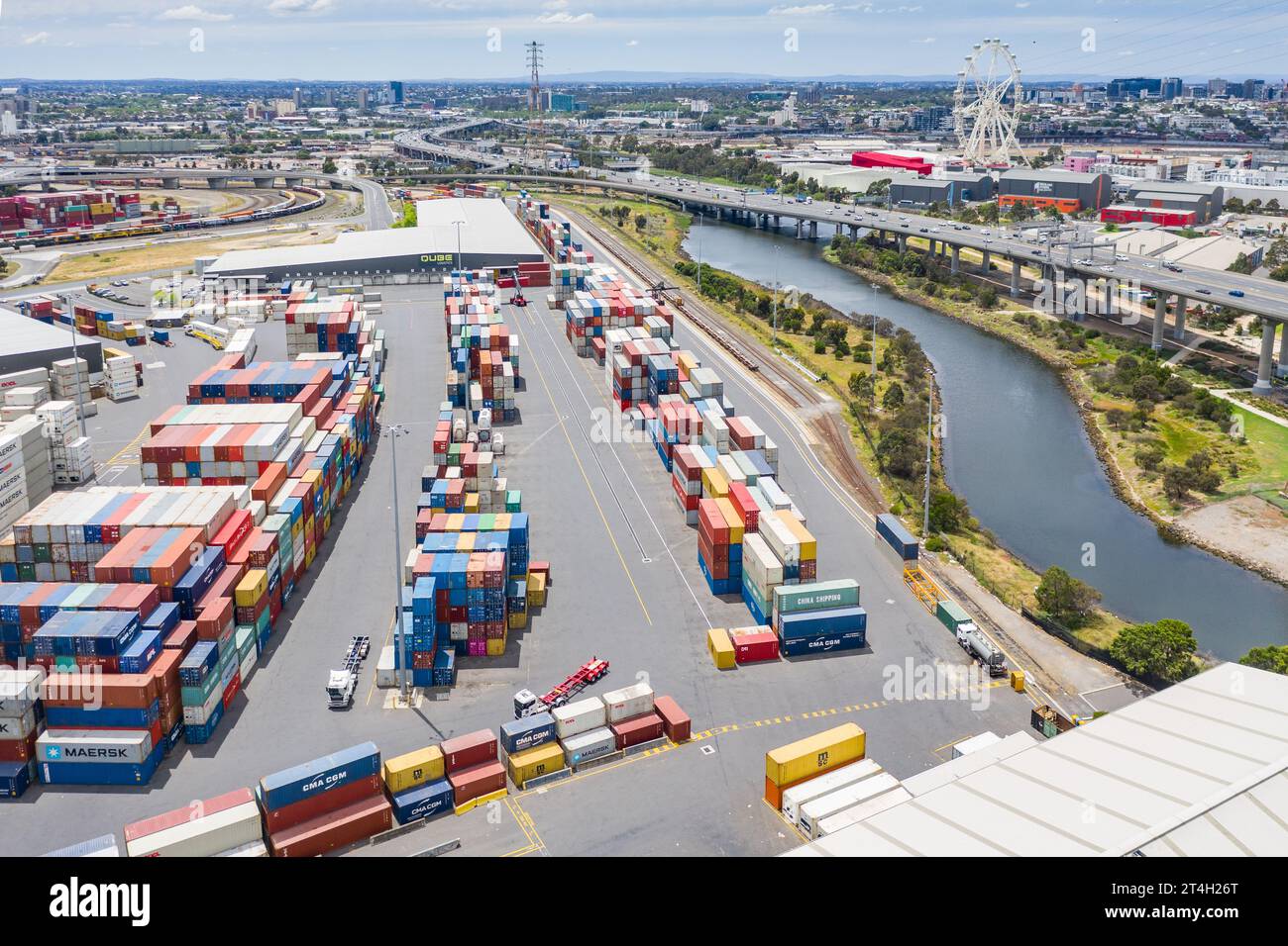 Aerial view of containers stacked on a wharf alongside a river at ...