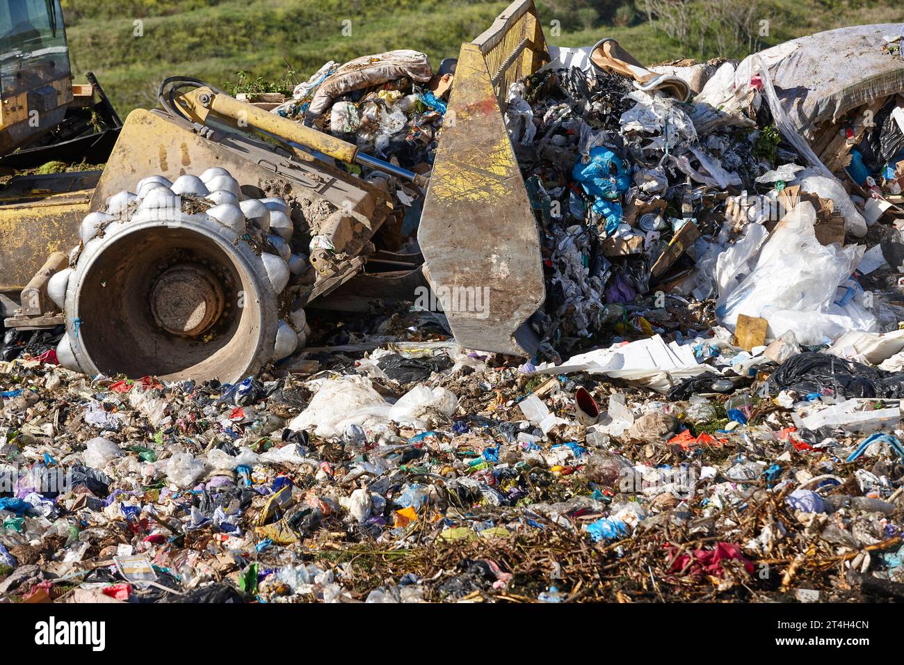 Heavy machinery shredding garbage in an open air landfill. Waste Stock ...
