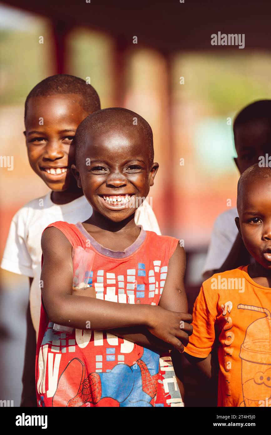 The three happy children wearing red and orange clothes smiling at the ...