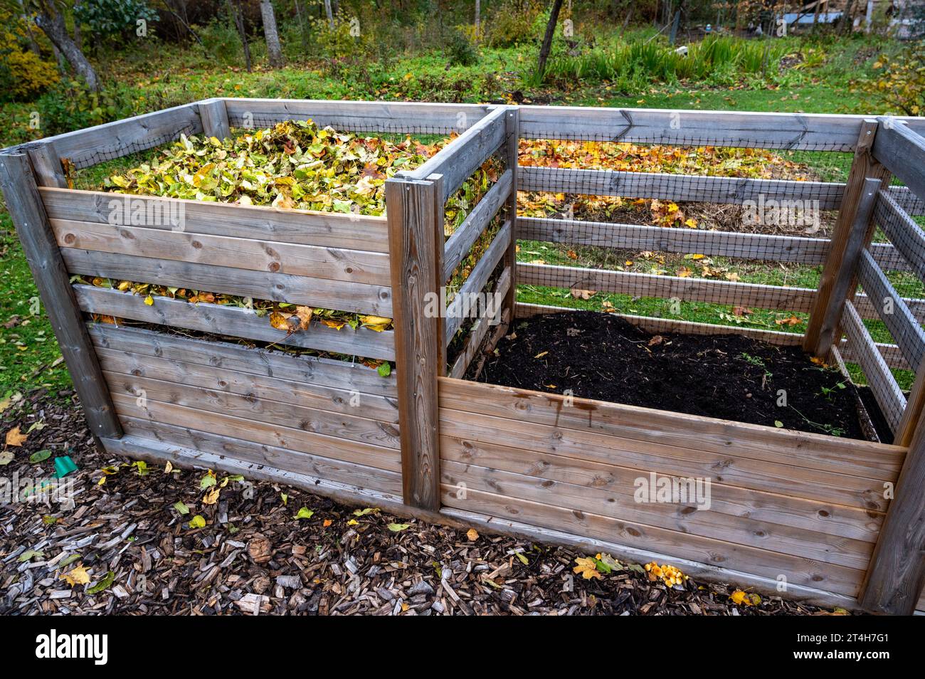 garden compost with one compartment full of leaves Stock Photo - Alamy