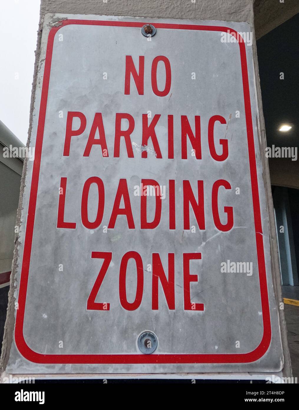no parking loading zone sign on yellow wall, close up Stock Photo - Alamy