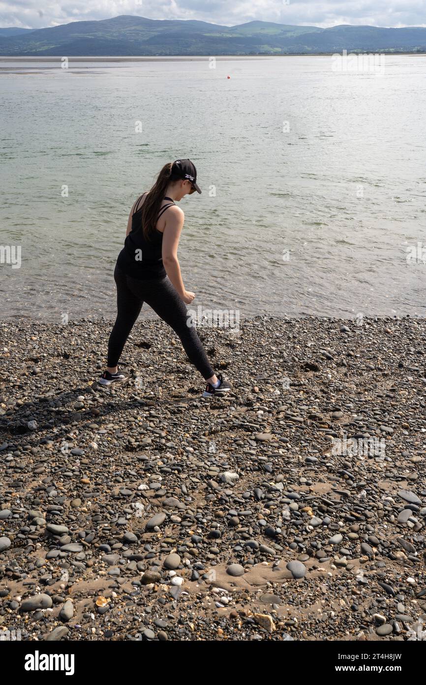 A young female skipping stones in the sea in Aberaeron Beach Stock Photo - Alamy