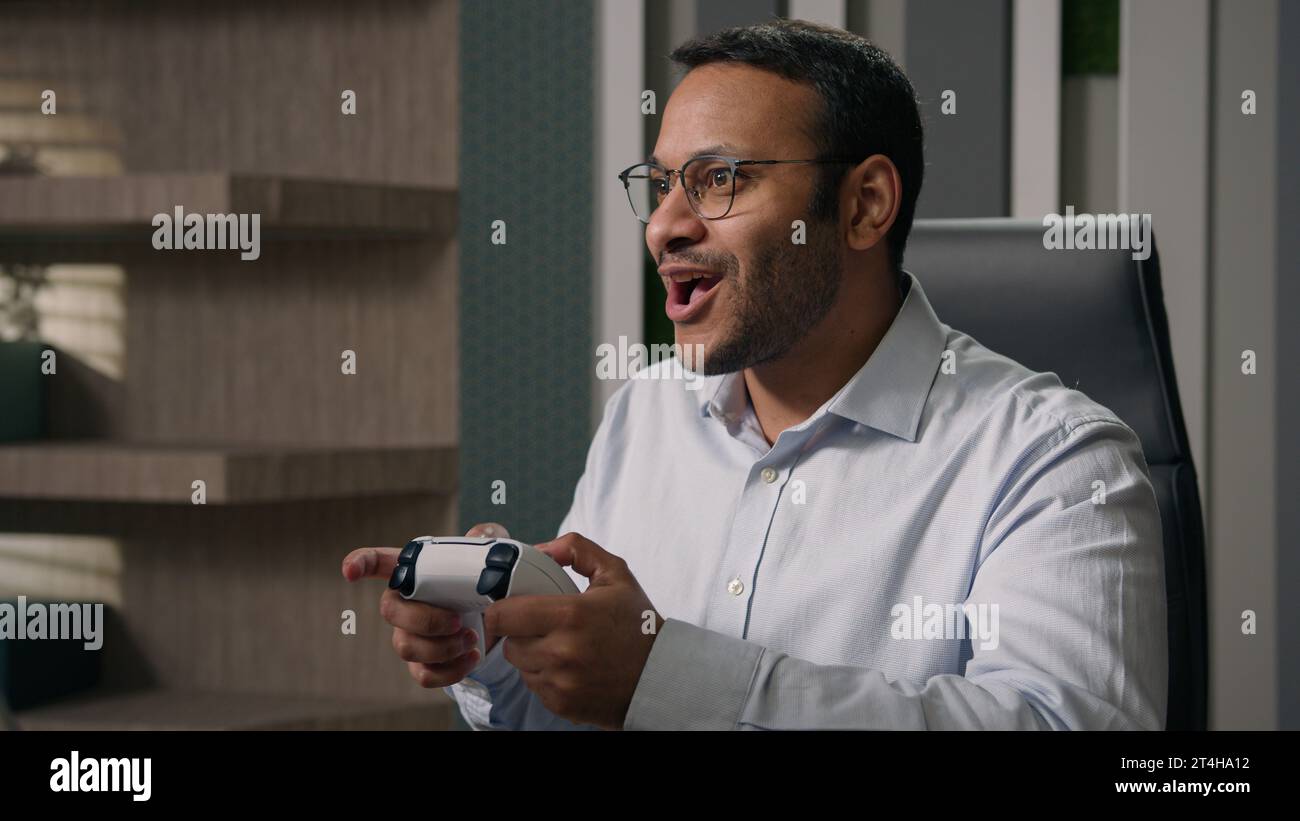 Funny lazy worker addicted video game Indian man playing console ...