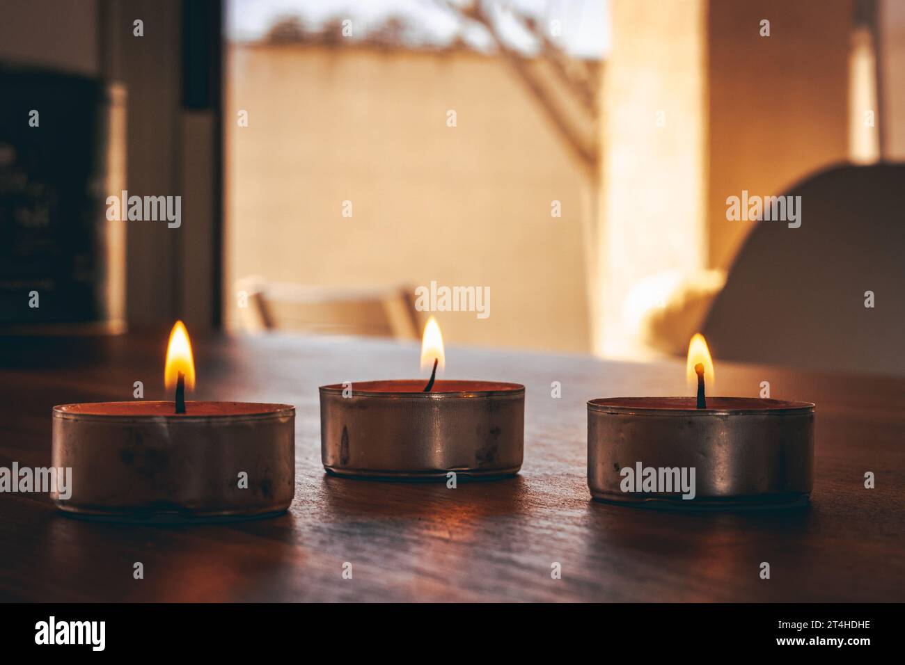 Burning candles placed against window with curtain during aromatherapy ...