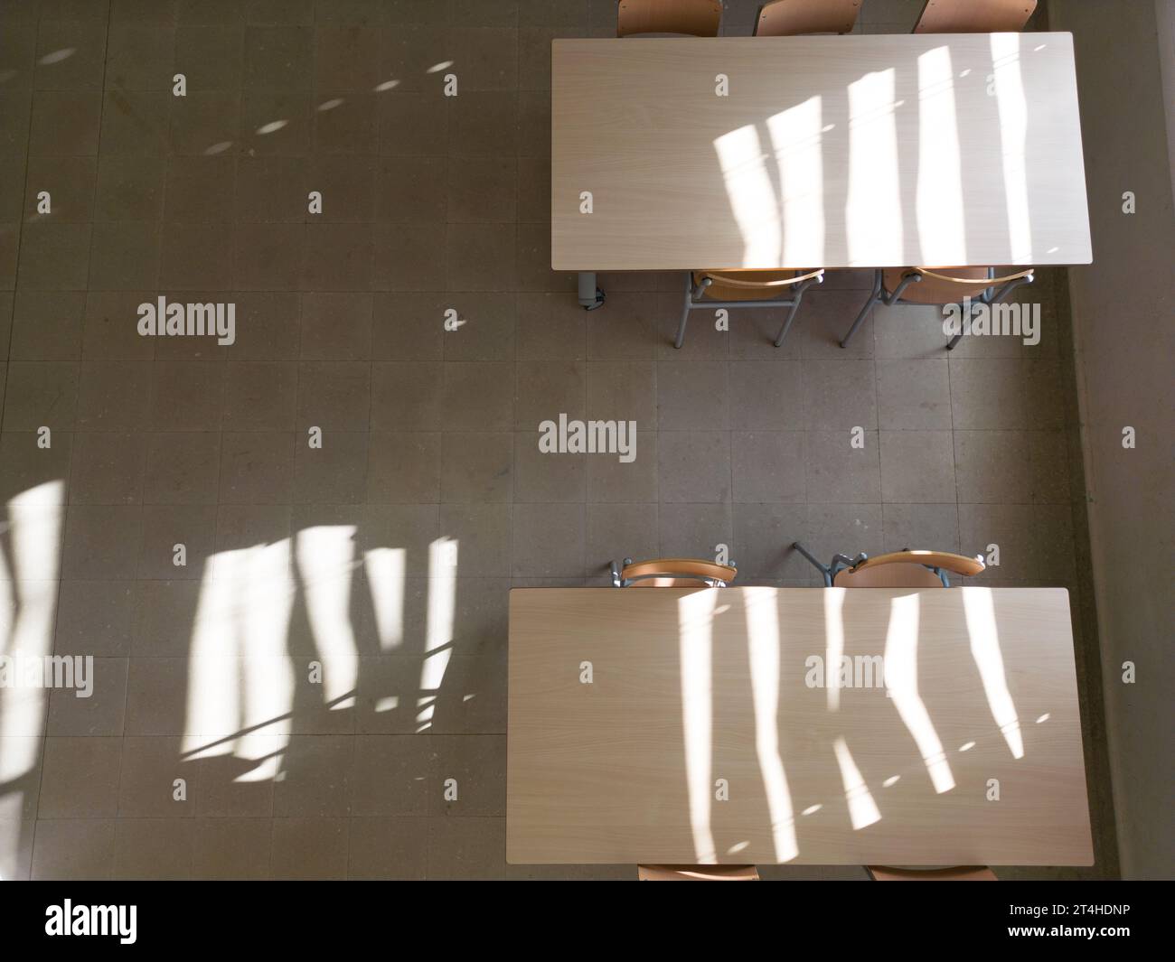Top view of similar upside down chairs placed on wooden table in light ...