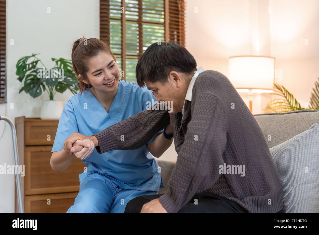 caregiver or nurse help support elderly are standing up without walker ...