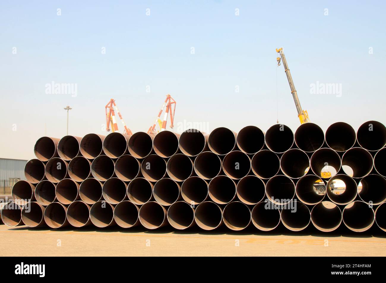 Piles of steel pipe and crane, closeup of photo Stock Photo - Alamy