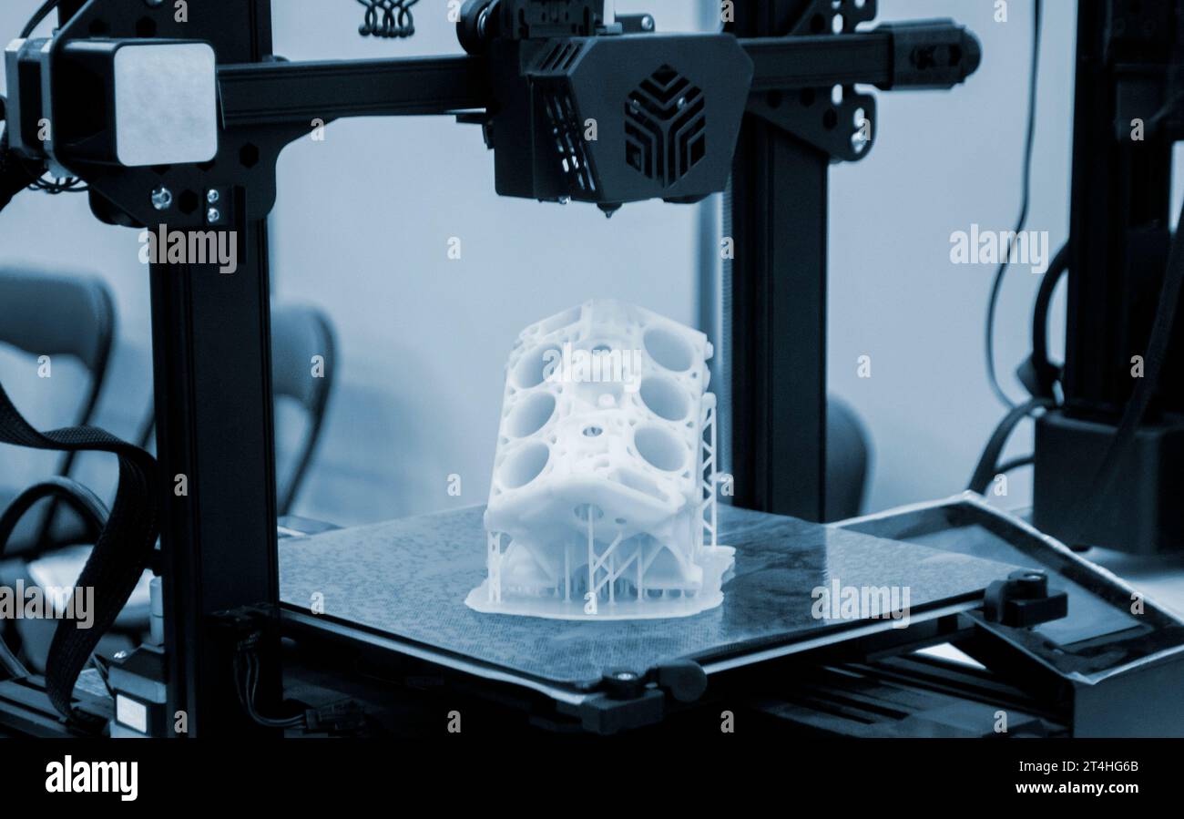 Prototype of car engine printed on 3D printer from molten white plastic on working surface 3D ...