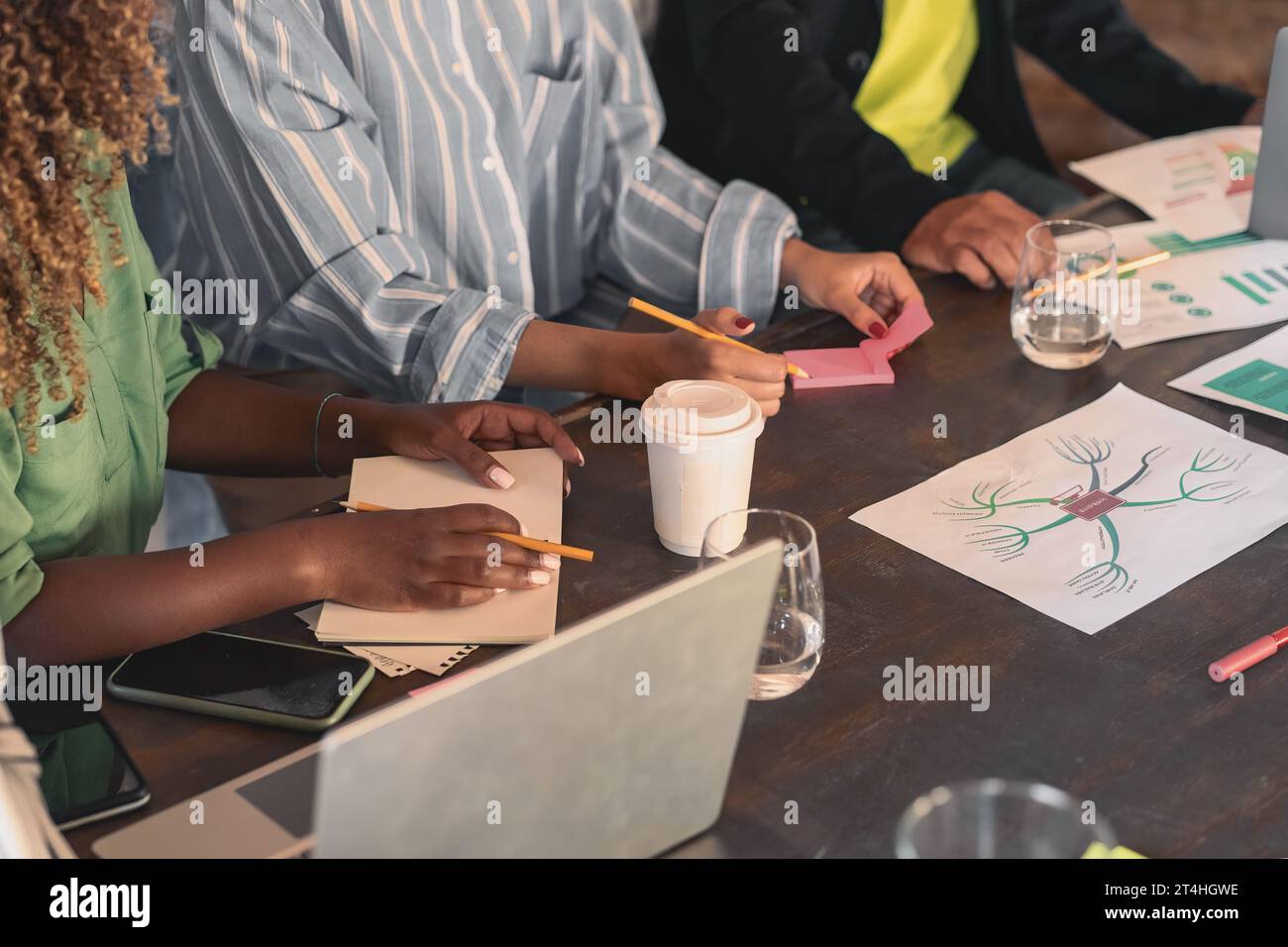 A group of professionals gather around a table, engaging in a ...