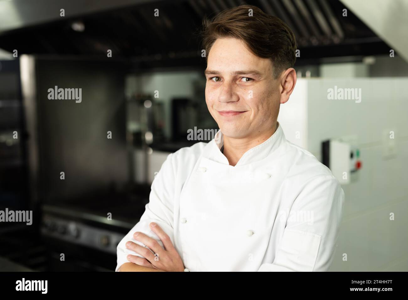Portrait of smiling caucasian male chef with arms crossed standing ...