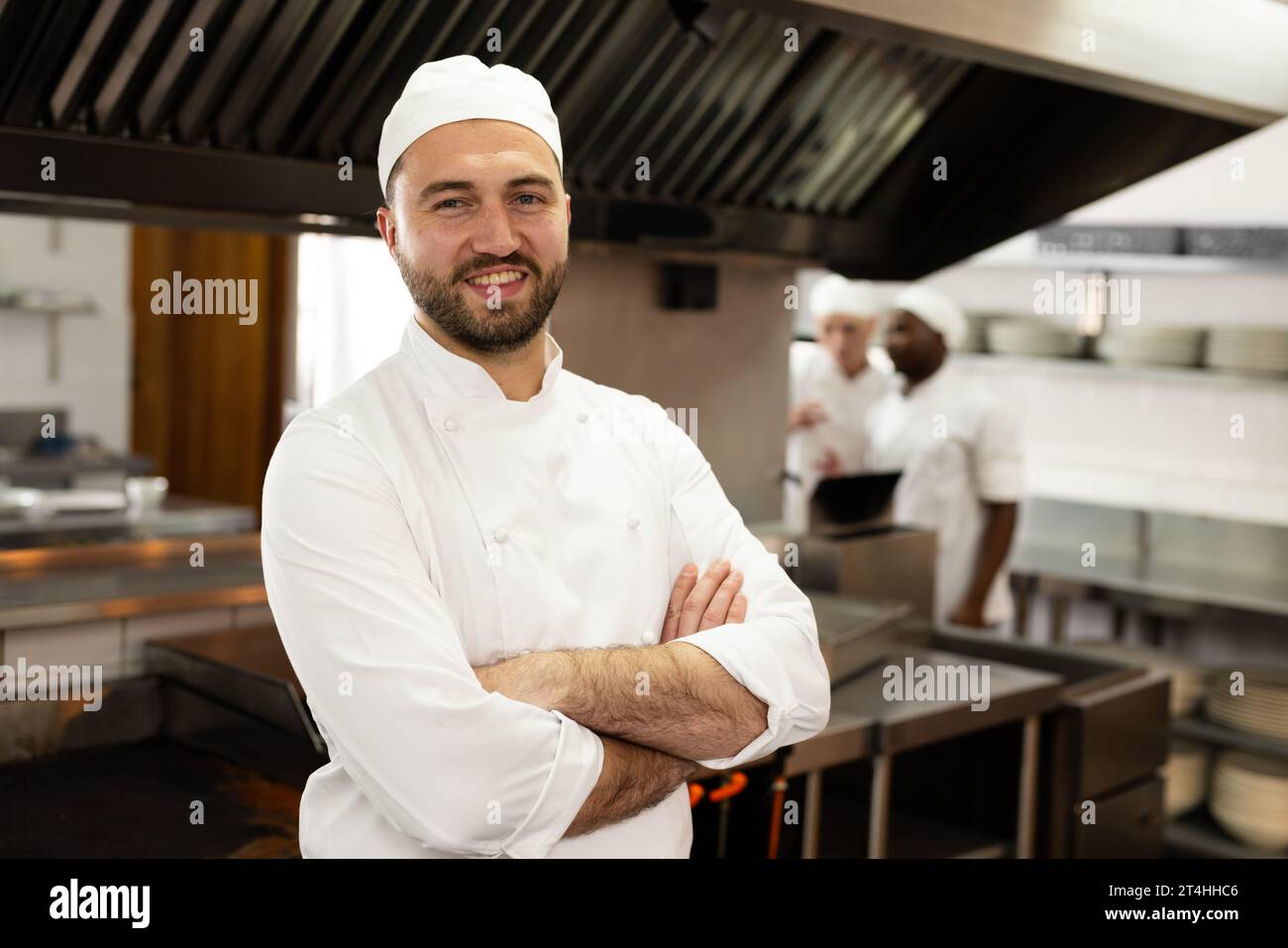 Portrait of smiling caucasian male chef in white uniform standing in ...