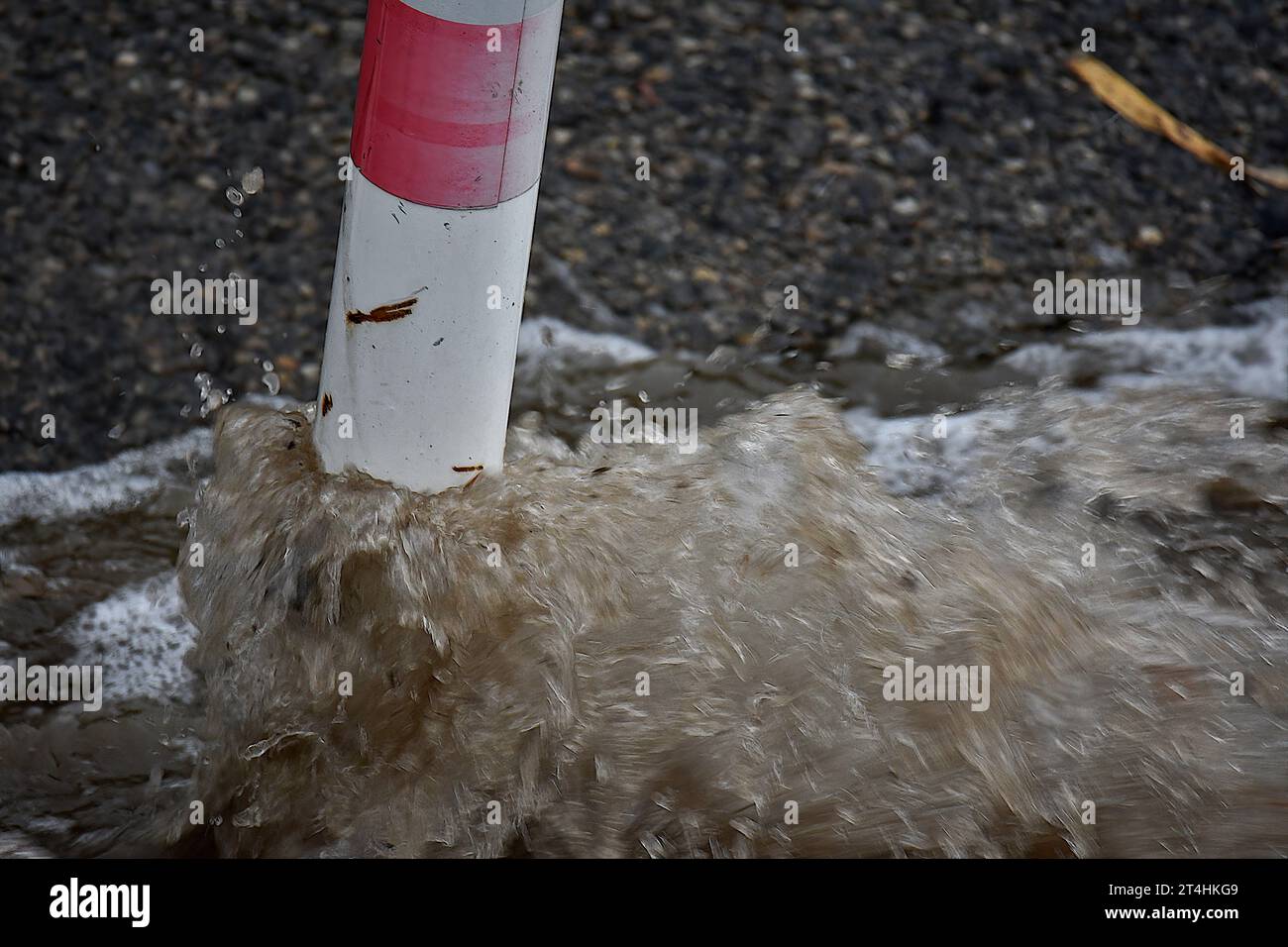 Muddy water from heavy rains overflows the gutters and spills onto the ...
