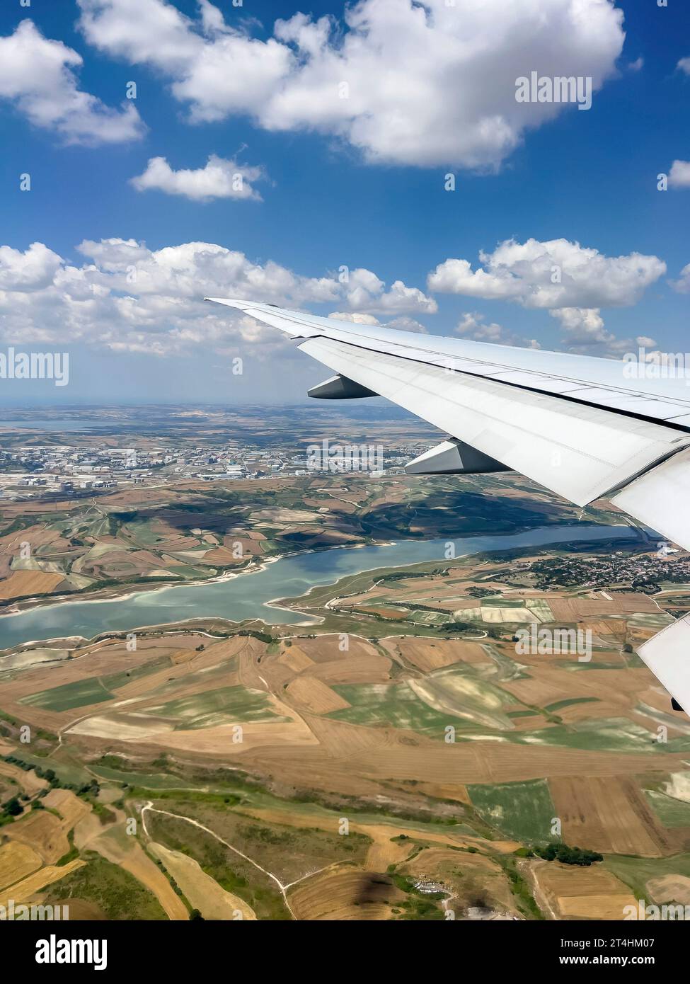 plane, wing of airplane flying in the air over city and river running ...