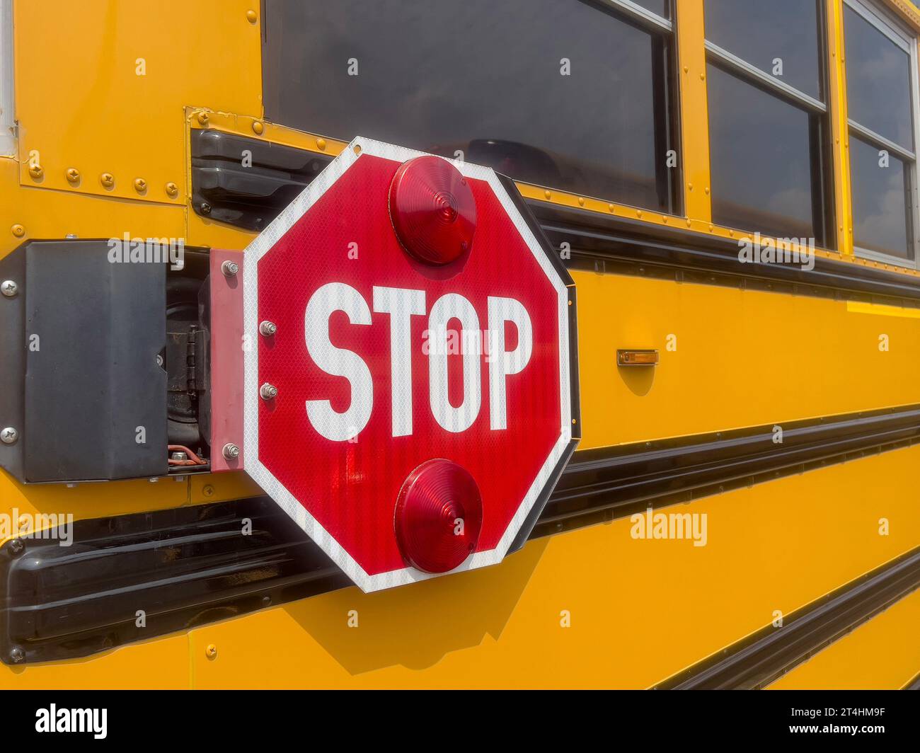 stop, closeup side view stop sign on iconic retro yellow school bus in ...