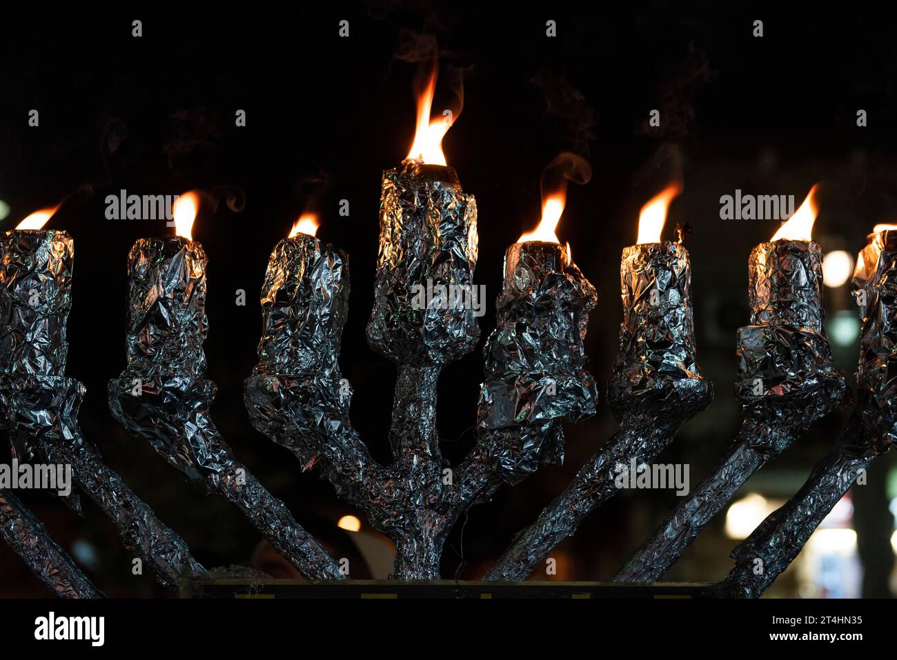 A large, public menorah wrapped in aluminum foil burns on the eighth ...
