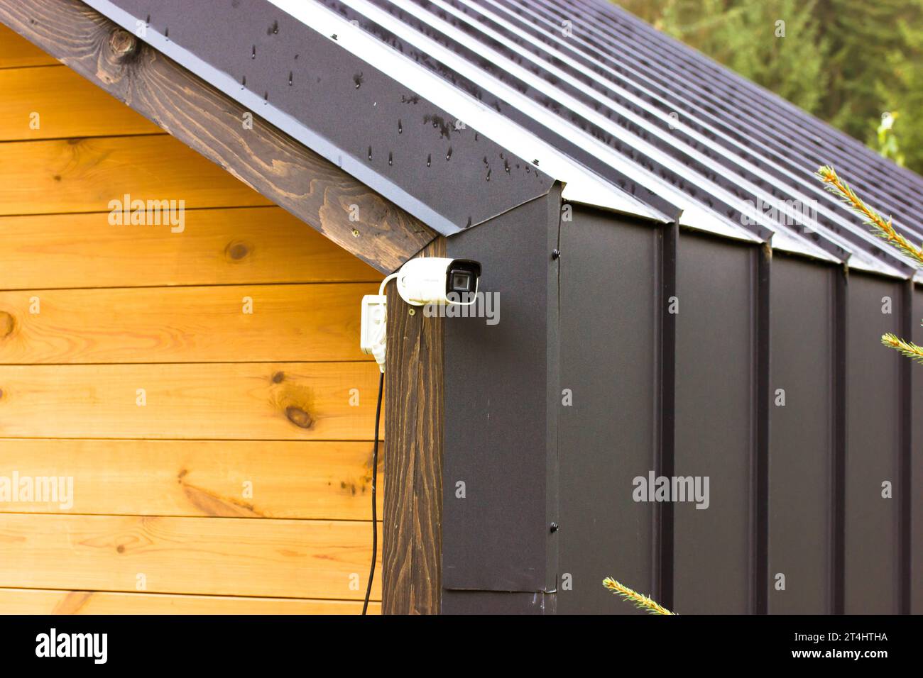 CCTV rotating surveillance video camera on a cottage house. Home ...