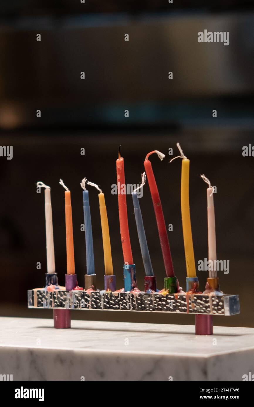Unlit and partially melted colorful Hanukkah candles on a menorah ...
