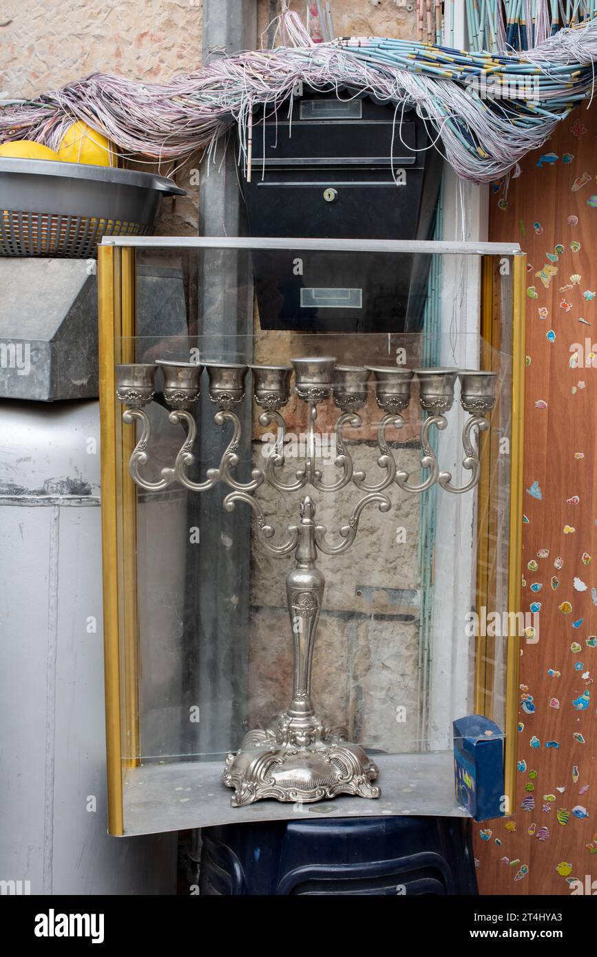 An unlit, silver Hanukkah menora stands idle during the daytime of the ...