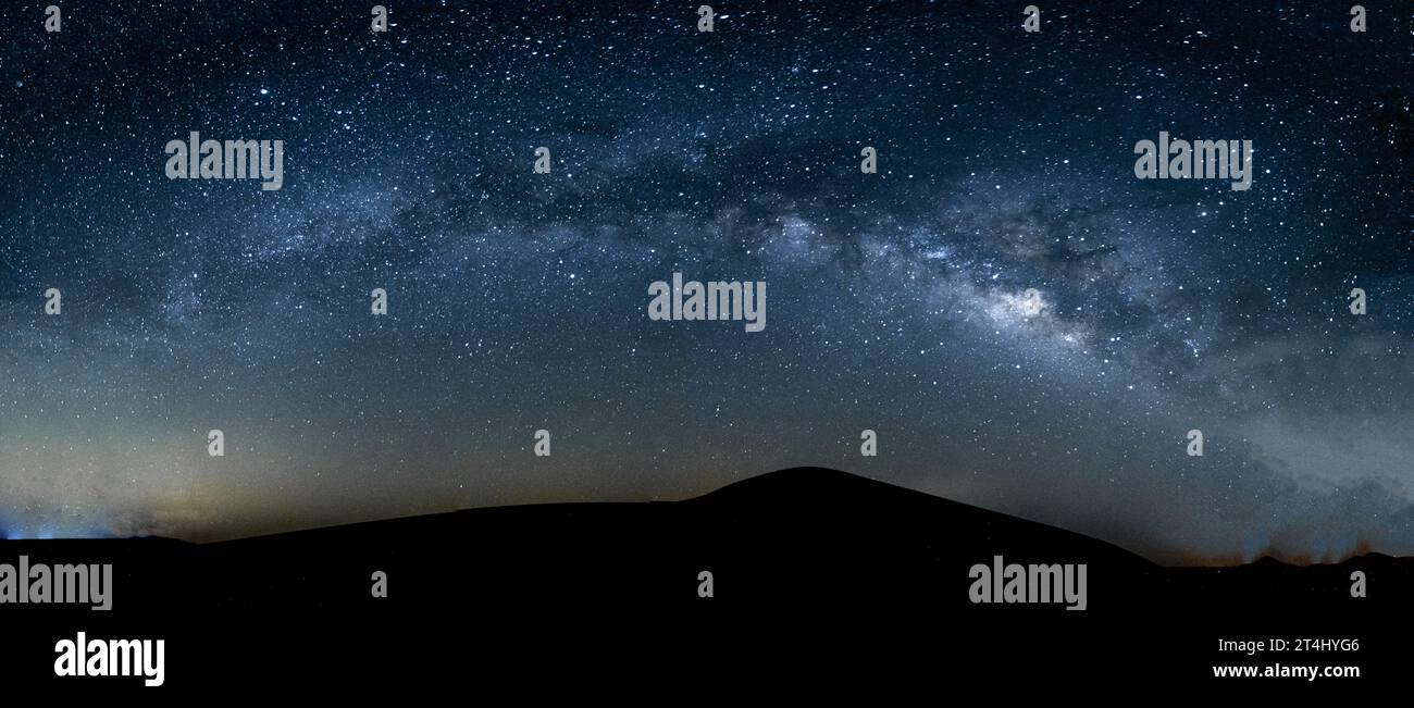 A stunning nightscape of a mountain range illuminated by a starry sky ...