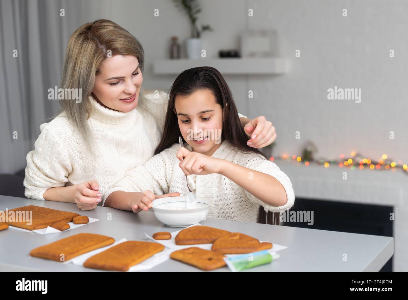 Family decorating gingerbread house on Christmas eve Stock Photo - Alamy