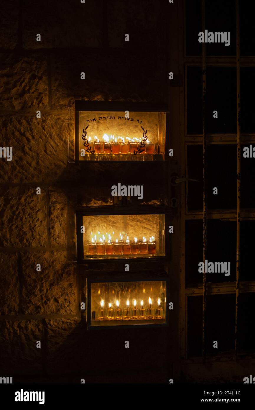 Glowing Hanukkah menorahs inscribed with a Hebrew phrase, "the candle ...