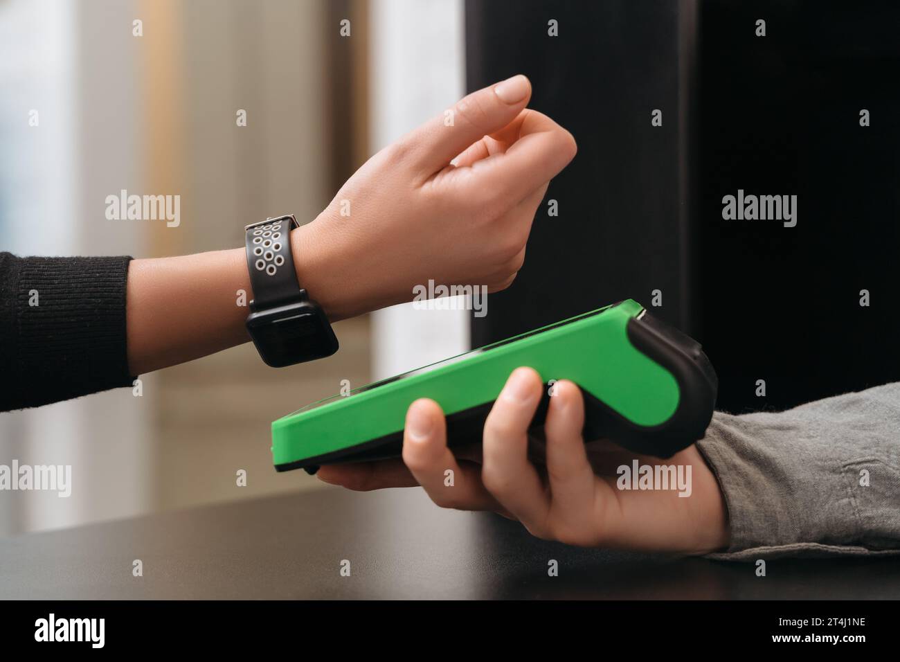 Closeup of modern lady paying via smartwatch while making purchase in ...