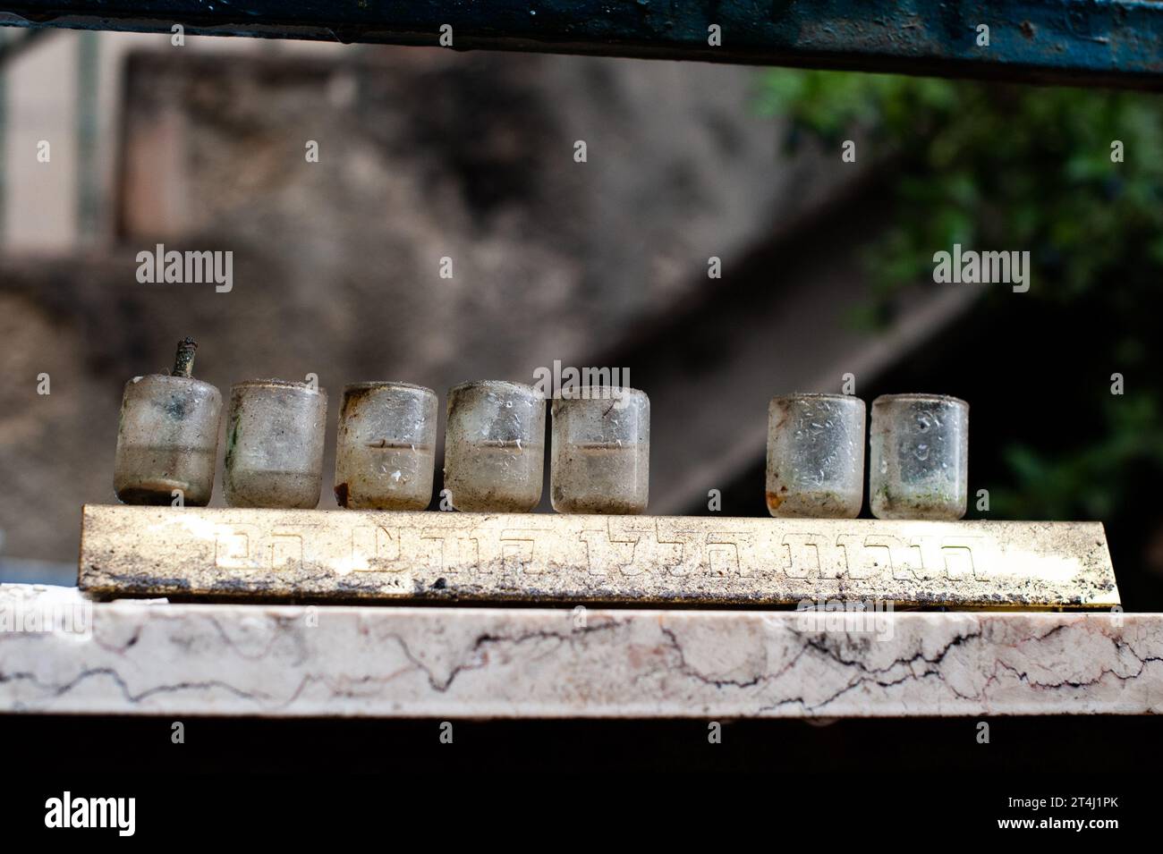 An unlit Hanukkah menorah inscribed with the Hebrew words, "These ...