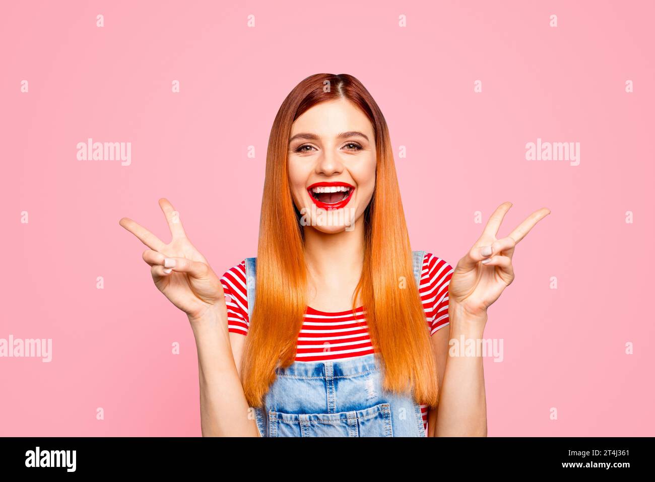 Young and pretty happy smiling woman in making v-sign with both hands ...
