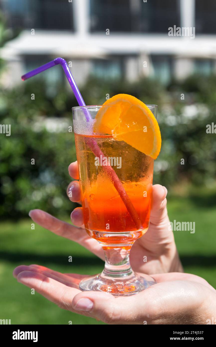 Orange cocktail with drinking straw in woman's hand, close-up Stock ...